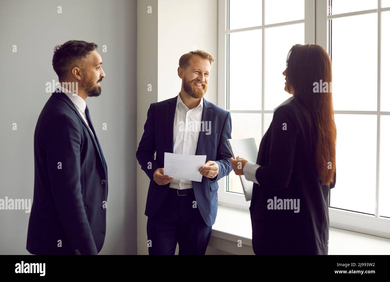 Business colleagues in formal suits have pleasant conversation during ...