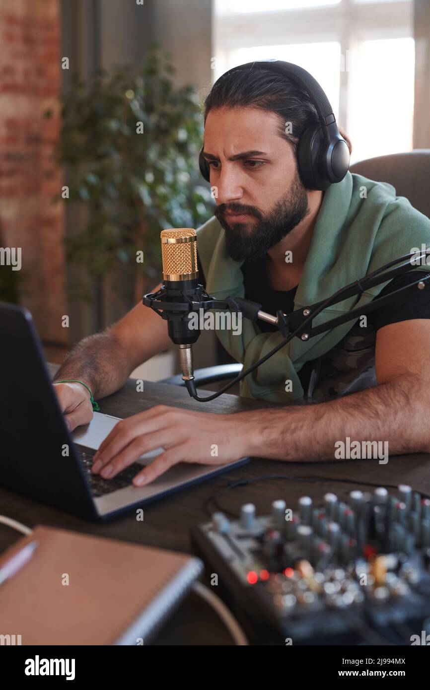 Vertical medium portrait of serious handsome man wearing headphones ...