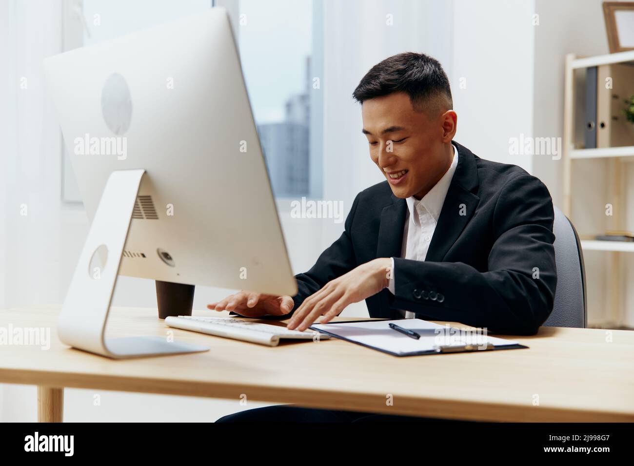 manager sitting at a desk in front of a computer Lifestyle Stock Photo ...