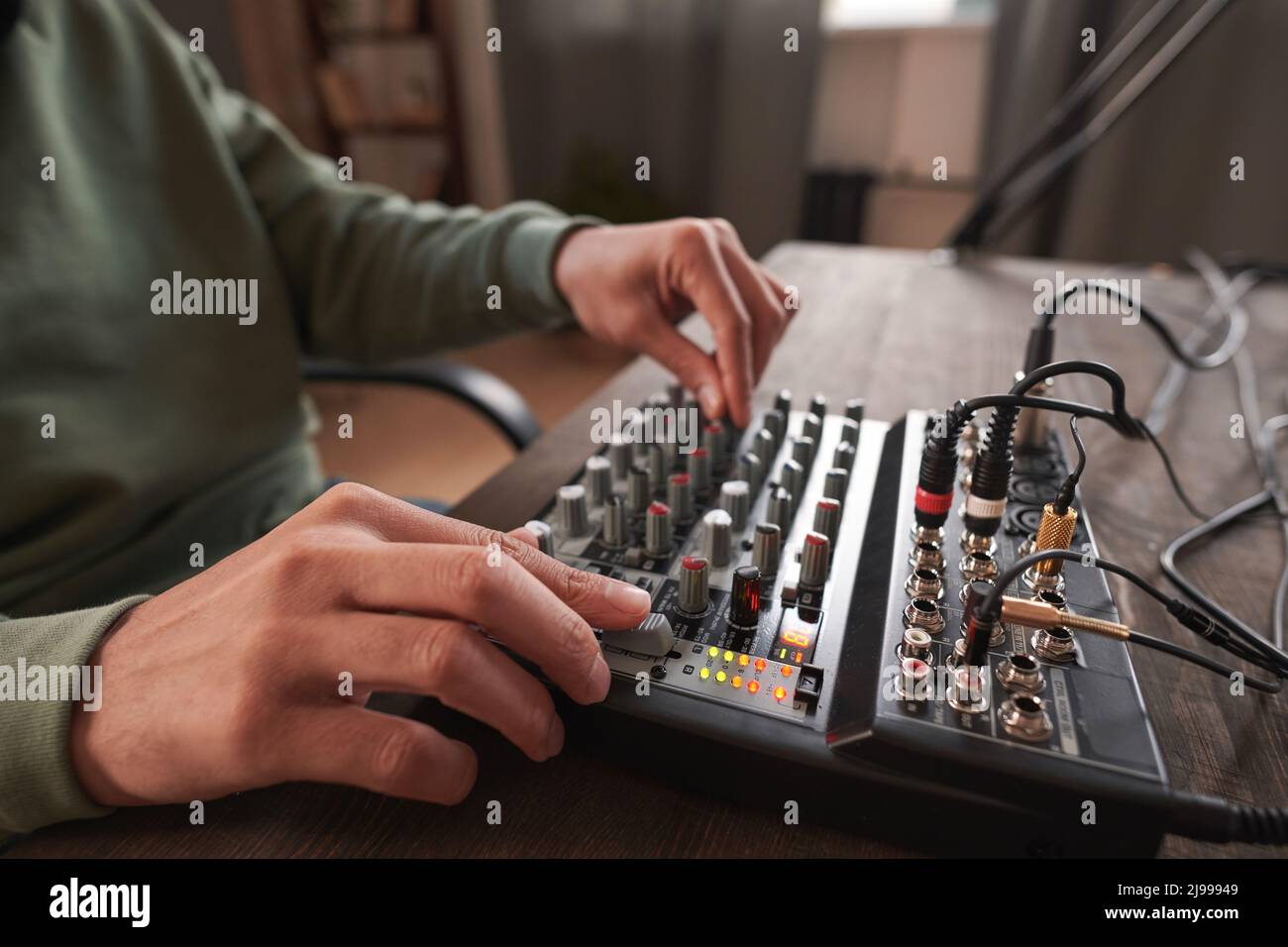 Medium close-up shot of unrecognizable young mans hands adjusting audio ...