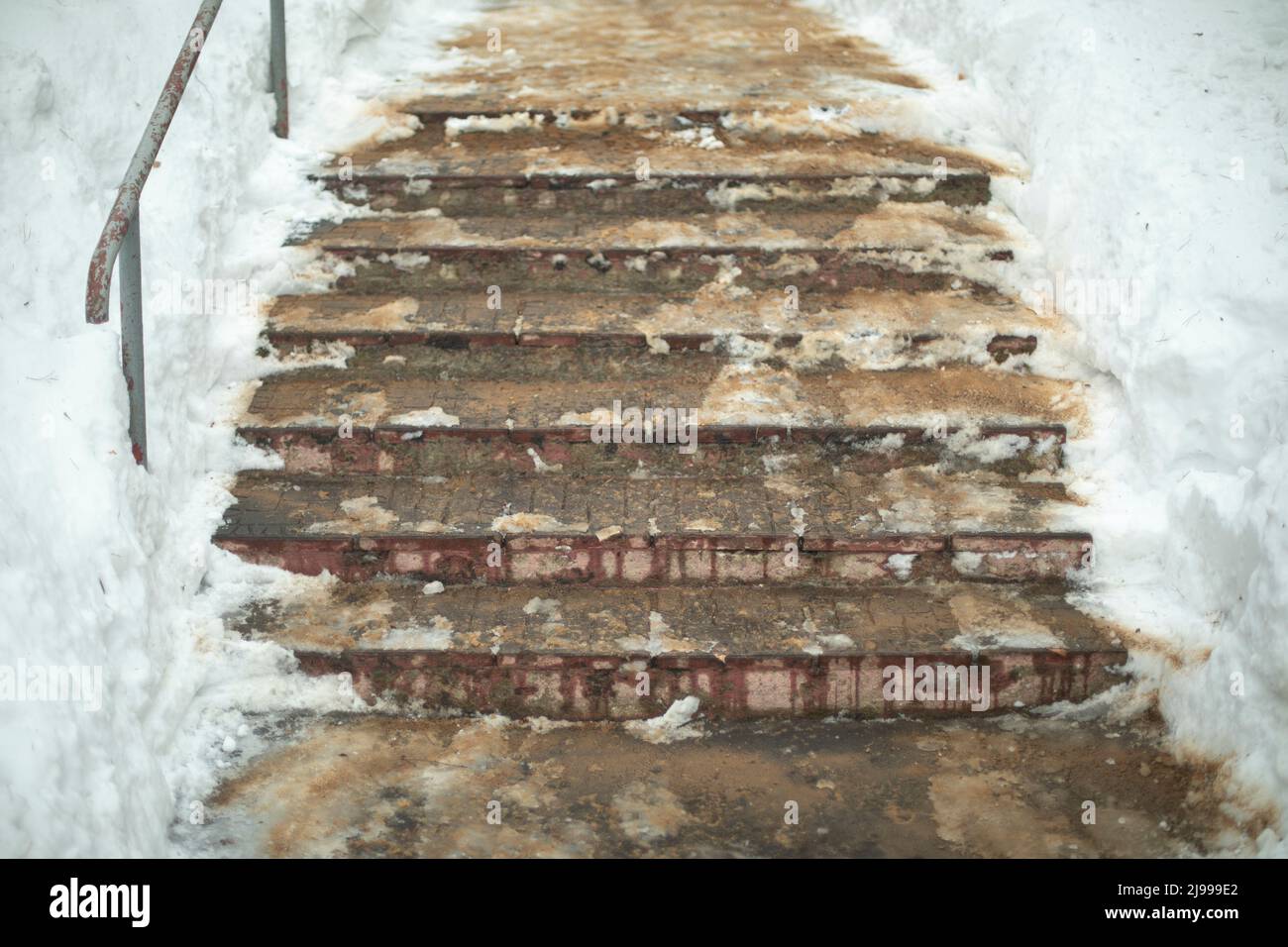 Dirty steps. Stairs outside. Steps in winter. Climbing hill. Handrail ...