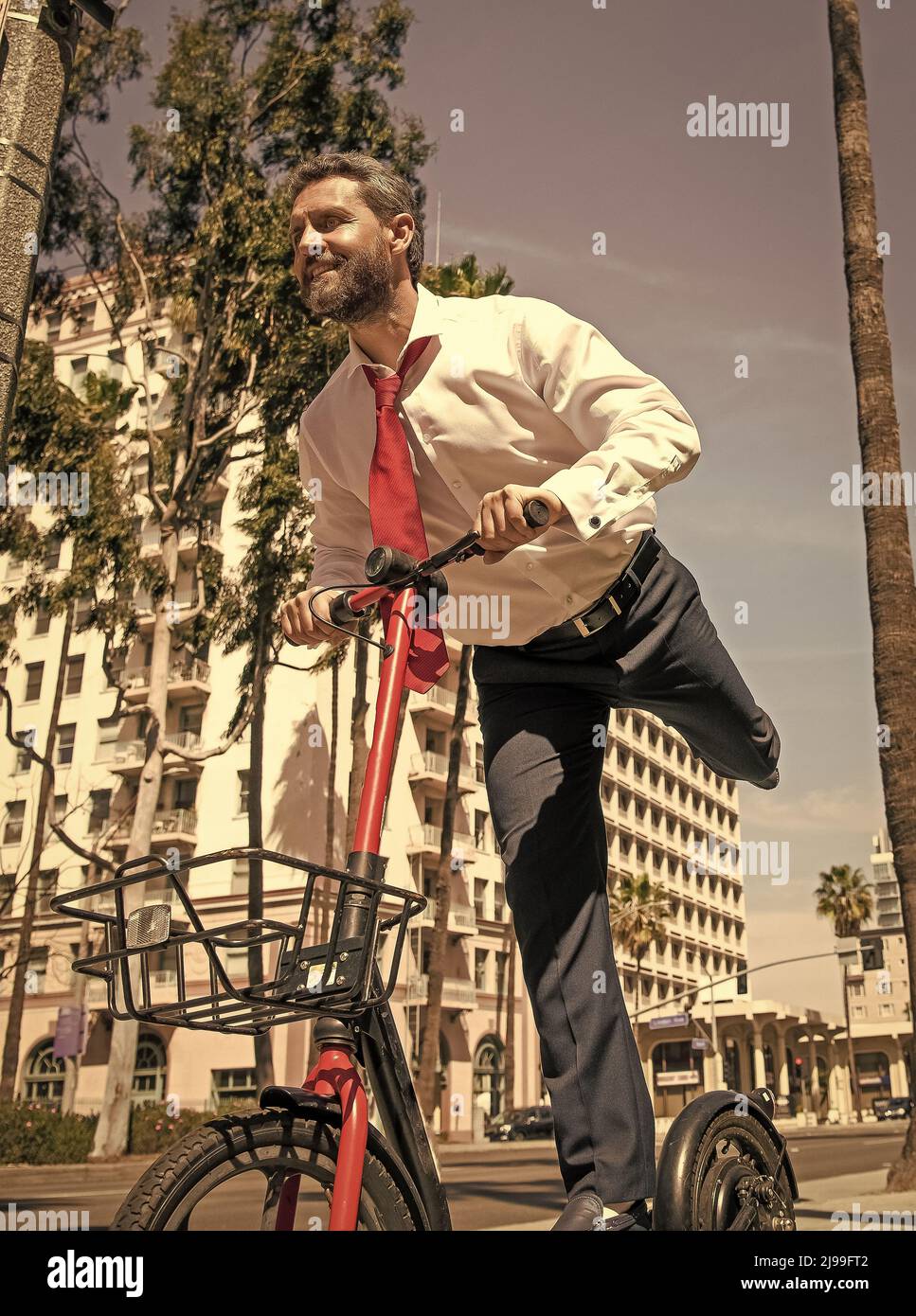 E-scooting is fun. Happy director have fun scooting along sidewalk ...