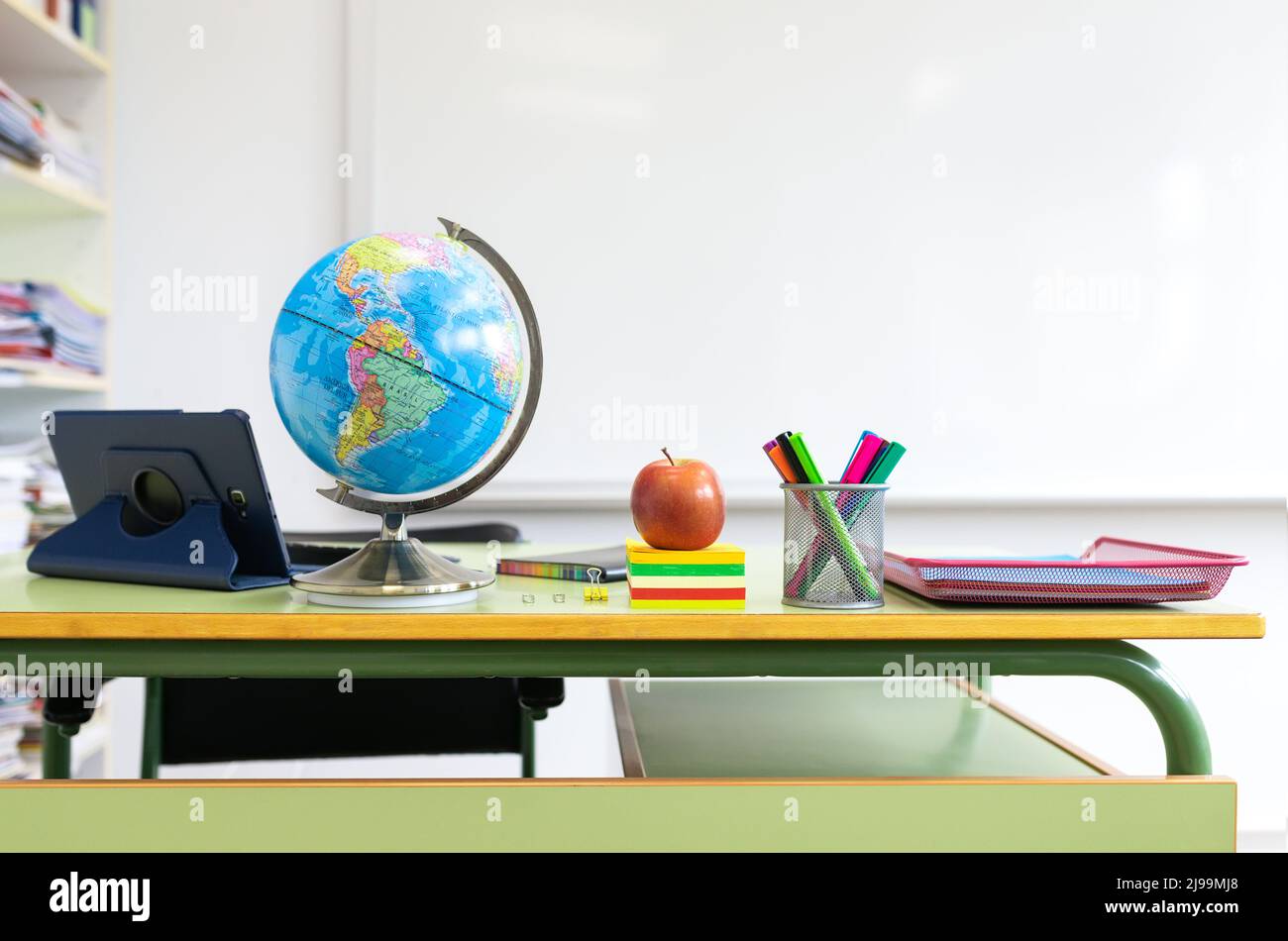 Detail of a school classroom. Teacher's table with objects on it ...