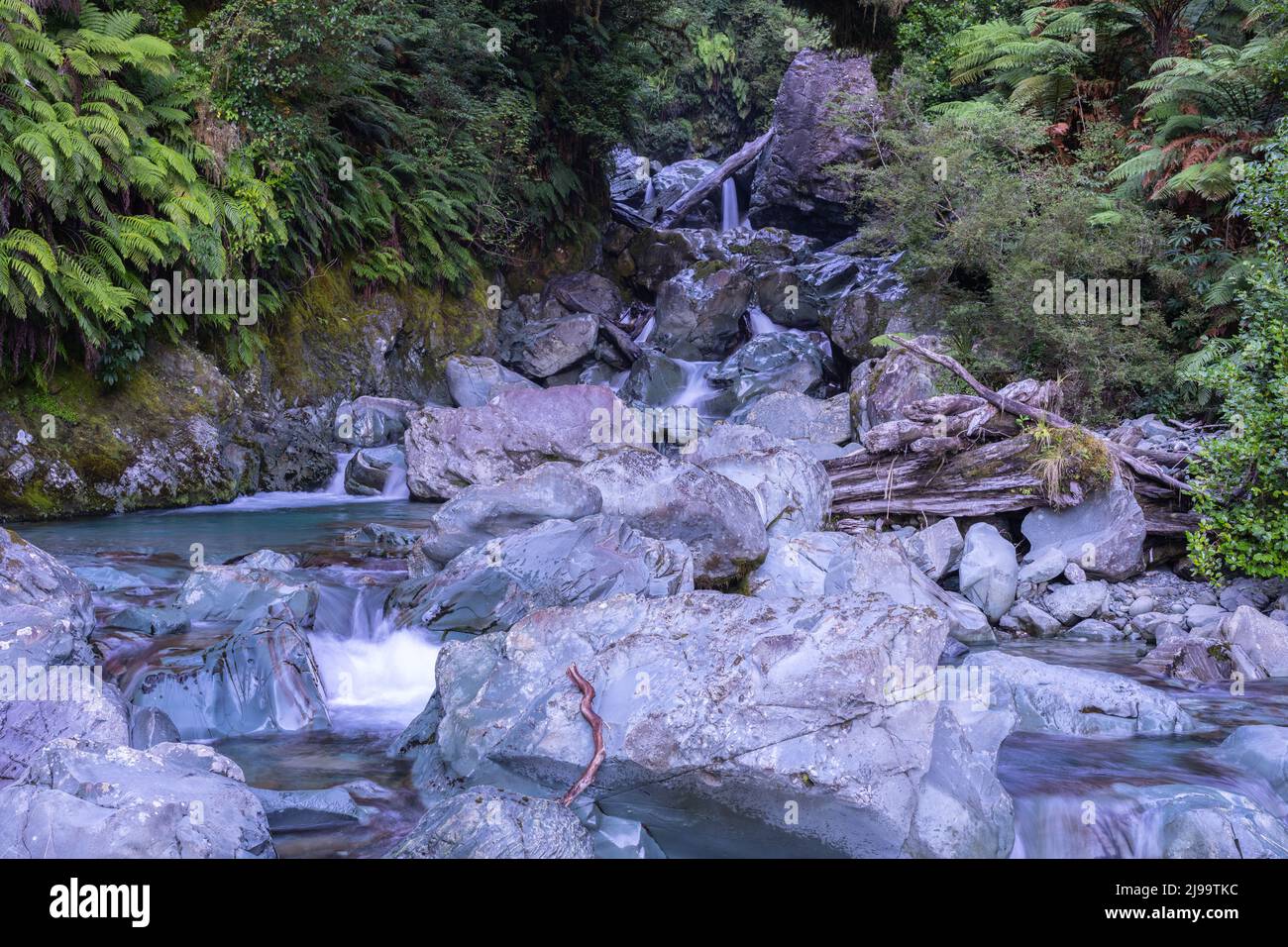 Small stream clean water flows and tumble across rocky terrain from ...