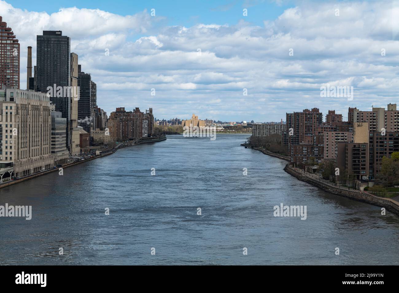 New York City skyscrapers on the river canal, cloudy and blue sky ...