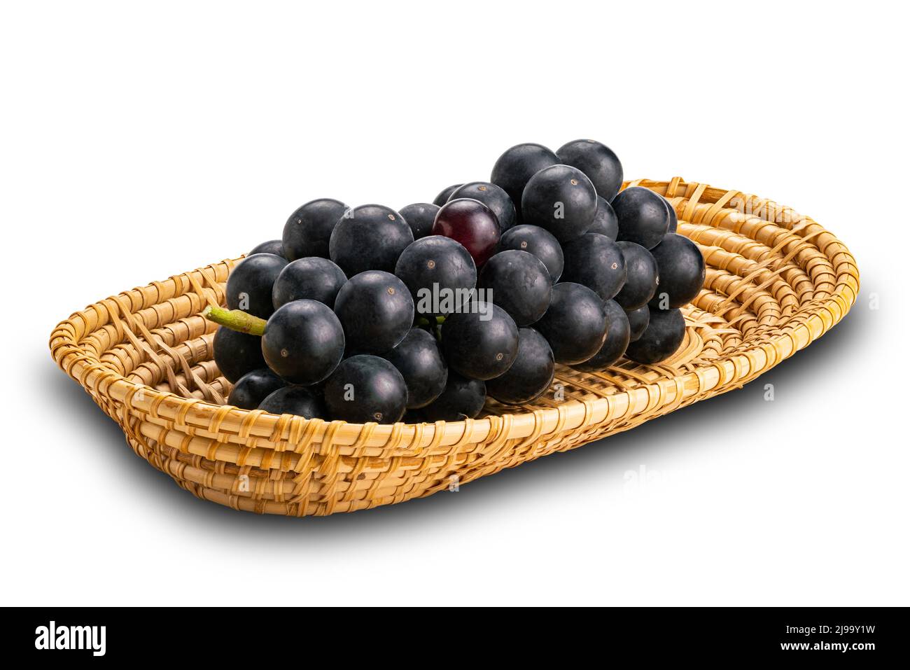 Bunch of ripe black grapes in bamboo tray isolated on white background ...