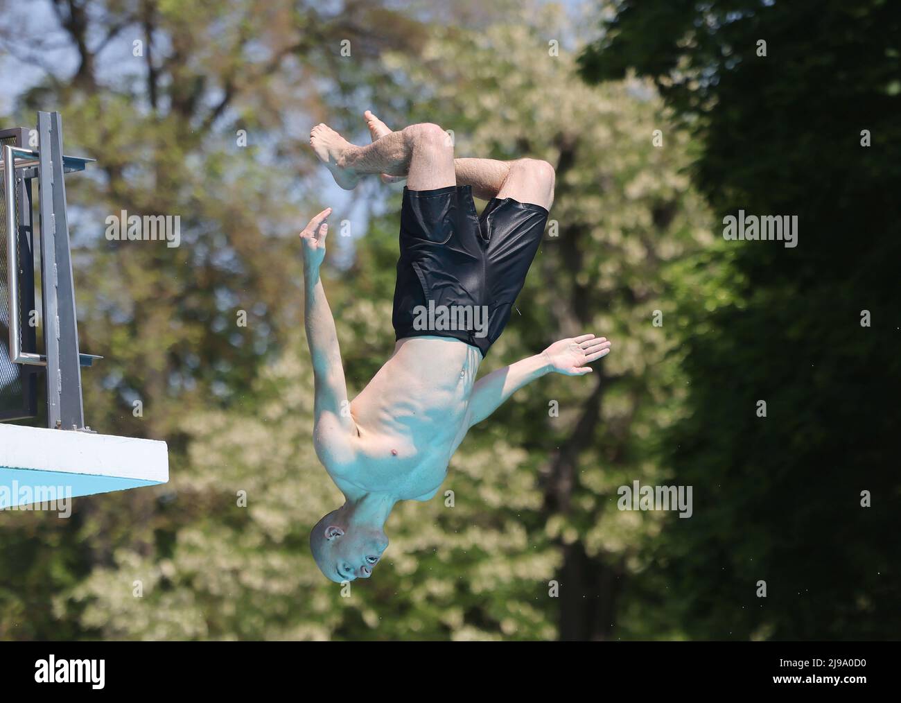 Cologne, Germany. 18th May, 2022. A man jumps from the ten-meter tower ...