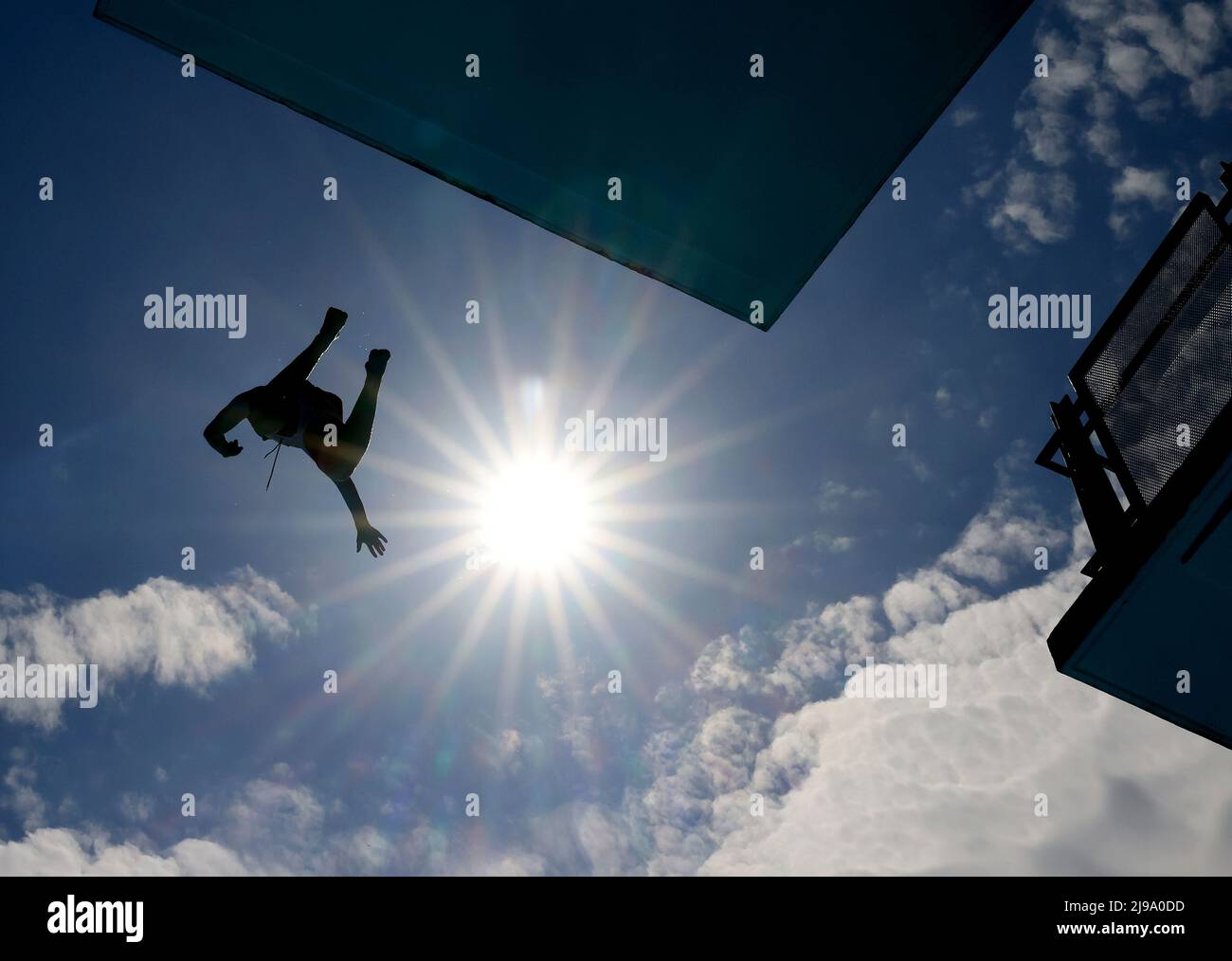 Cologne, Germany. 18th May, 2022. A man jumps from the ten-meter tower ...