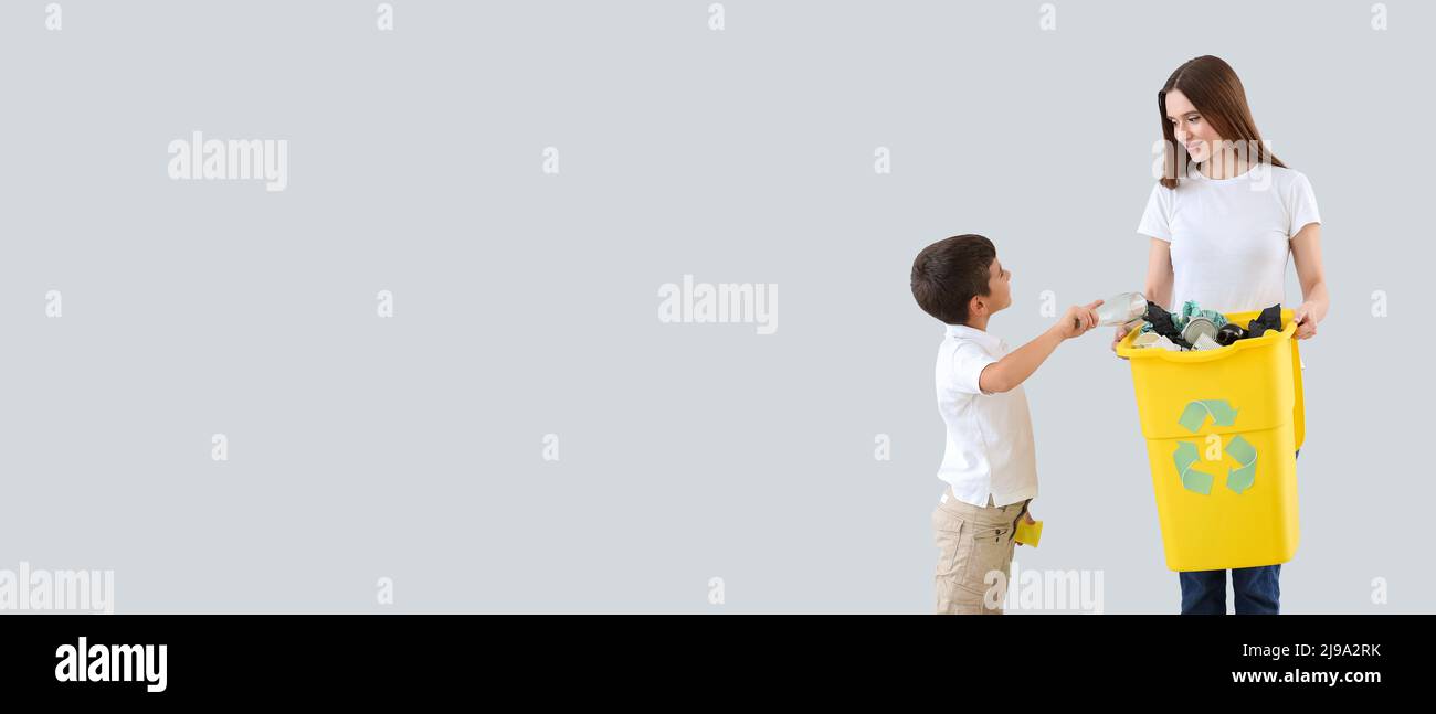 Mother and son with container for garbage on light background with ...