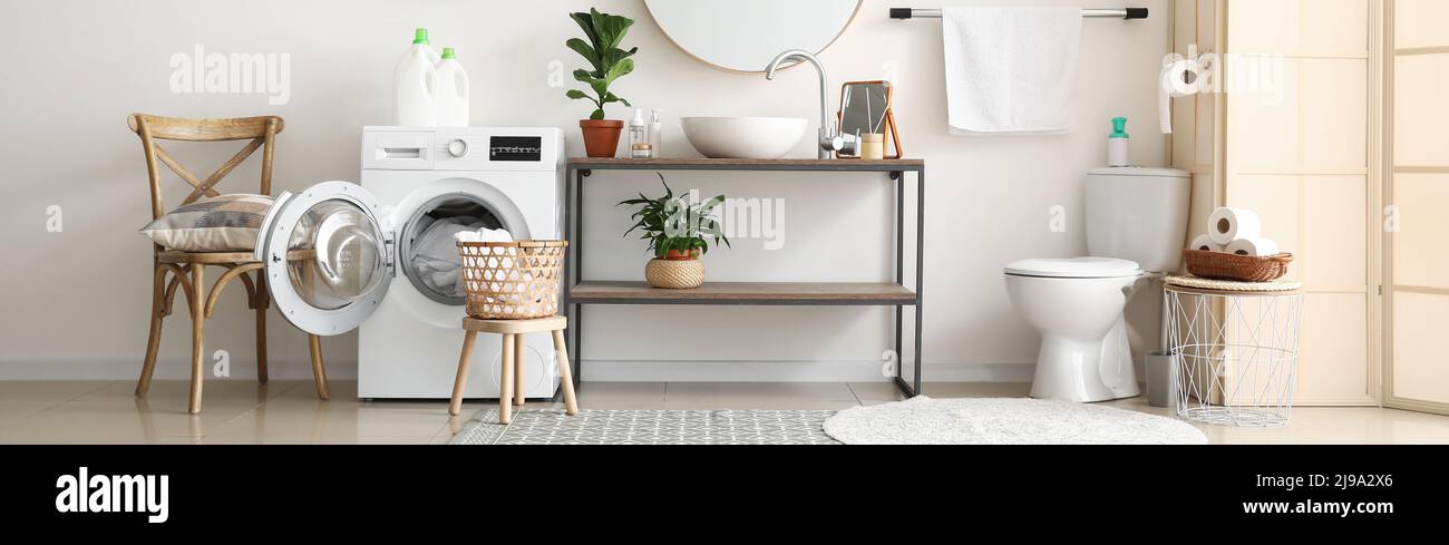 Interior of bathroom with modern washing machine, sink and toilet bowl ...
