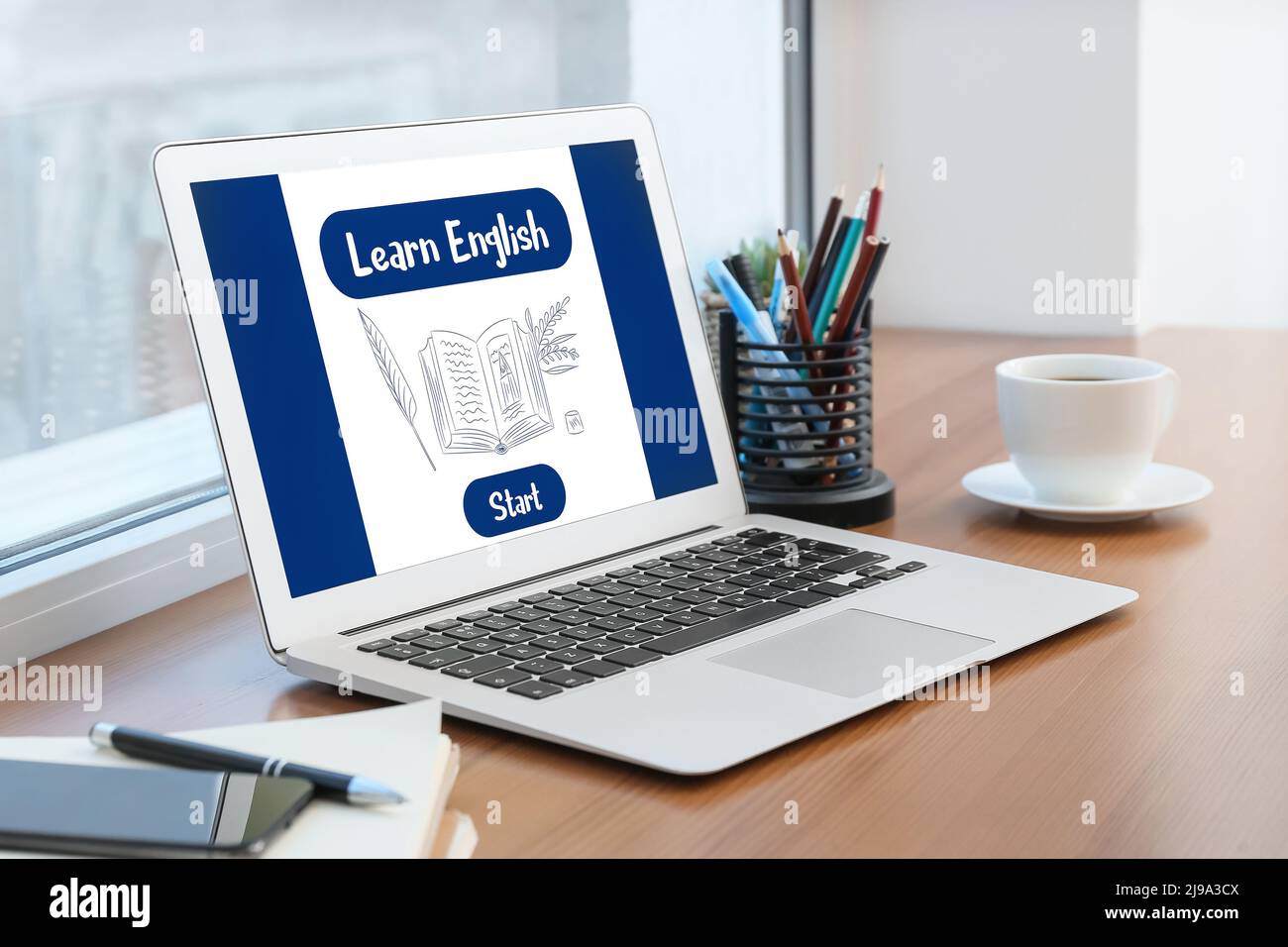 Modern laptop with text LEARN ENGLISH on screen at workplace Stock ...