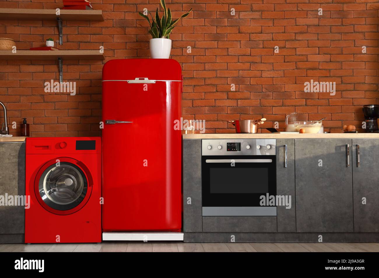 Interior of modern kitchen with red washing machine and fridge near ...