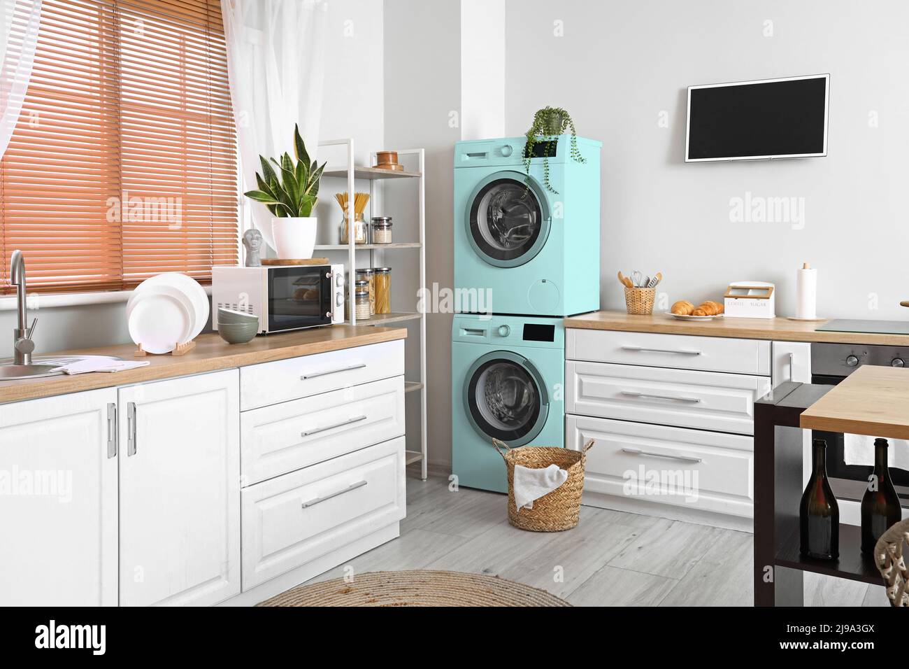 Interior of light modern kitchen with two washing machines and TV Stock ...