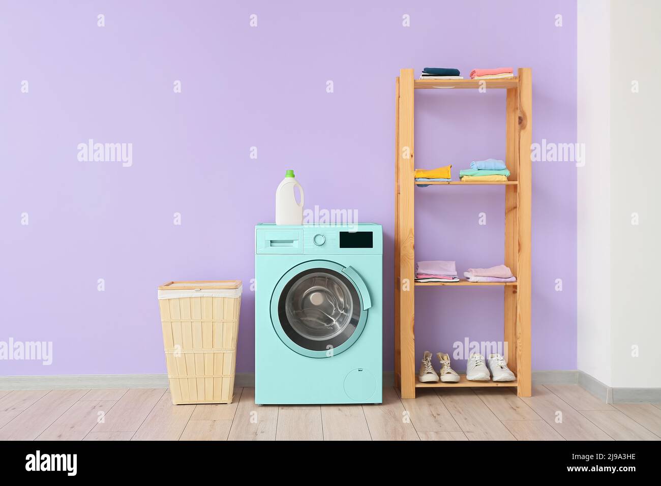 Interior of modern laundry room with turquoise washing machine, basket ...