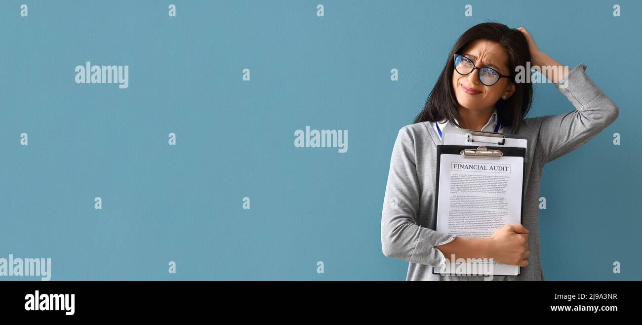 Worried female accountant with financial audit on blue background with ...