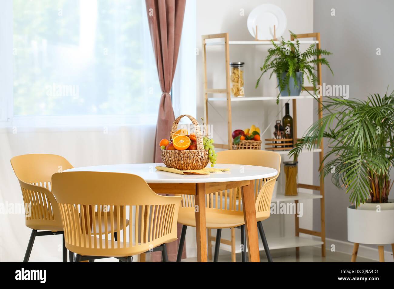 Interior of dining room with table and wicker fruit basket Stock Photo ...