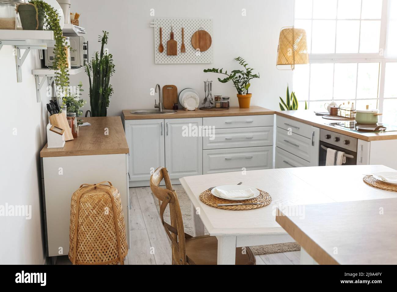Interior of light kitchen with stylish counters, kitchenware and ...