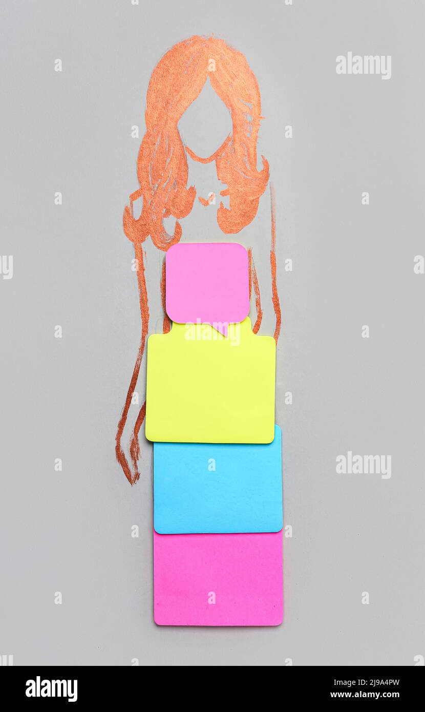 Silhouette of woman with dress made of sticky notes on grey background ...