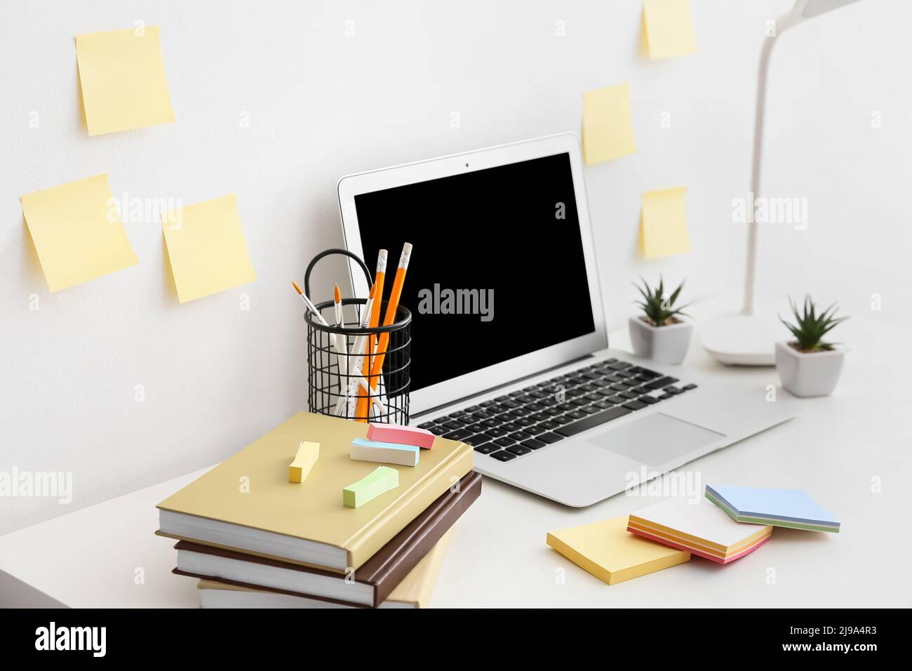 Workplace with notebooks, blank sticky notes and modern laptop near ...