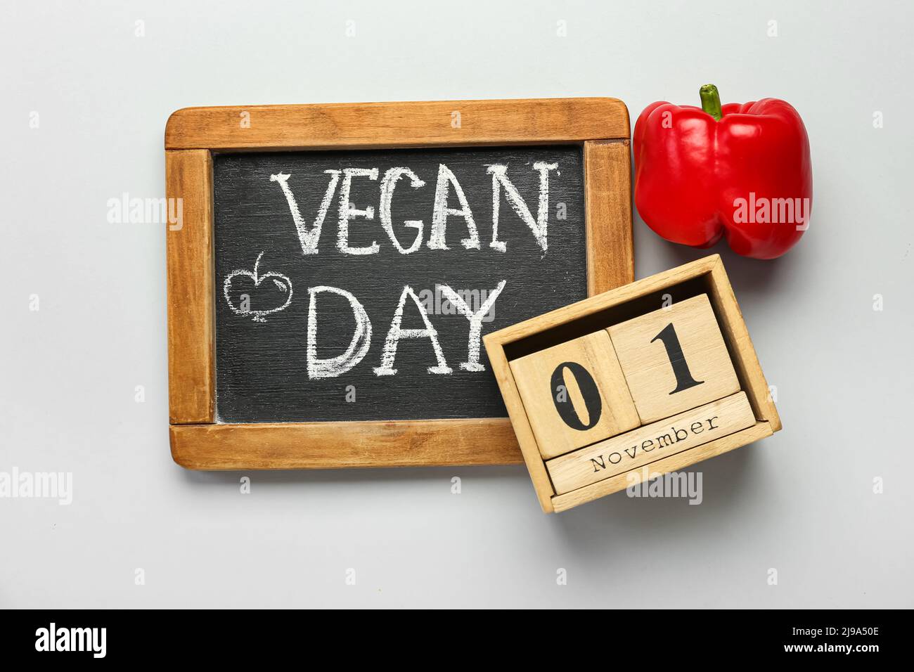 Wooden cube calendar with date NOVEMBER 1, bell pepper and board with ...