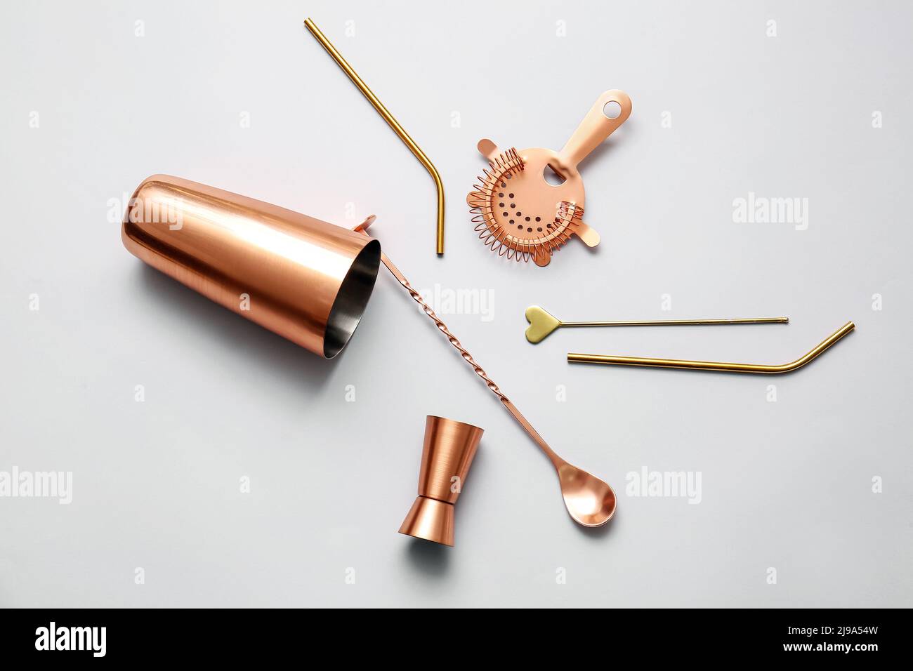 Copper bartender tools on grey background Stock Photo - Alamy