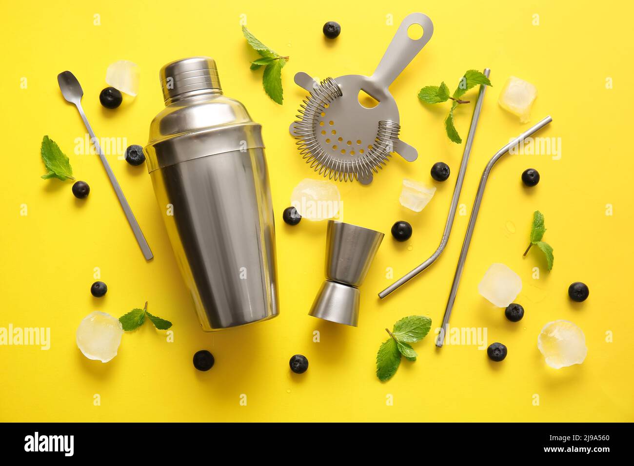 Different bartender tools and cocktail ingredients on yellow background ...