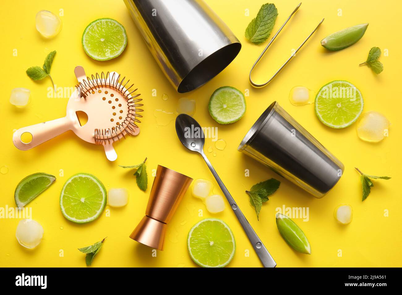 Different bartender tools and cocktail ingredients on yellow background ...