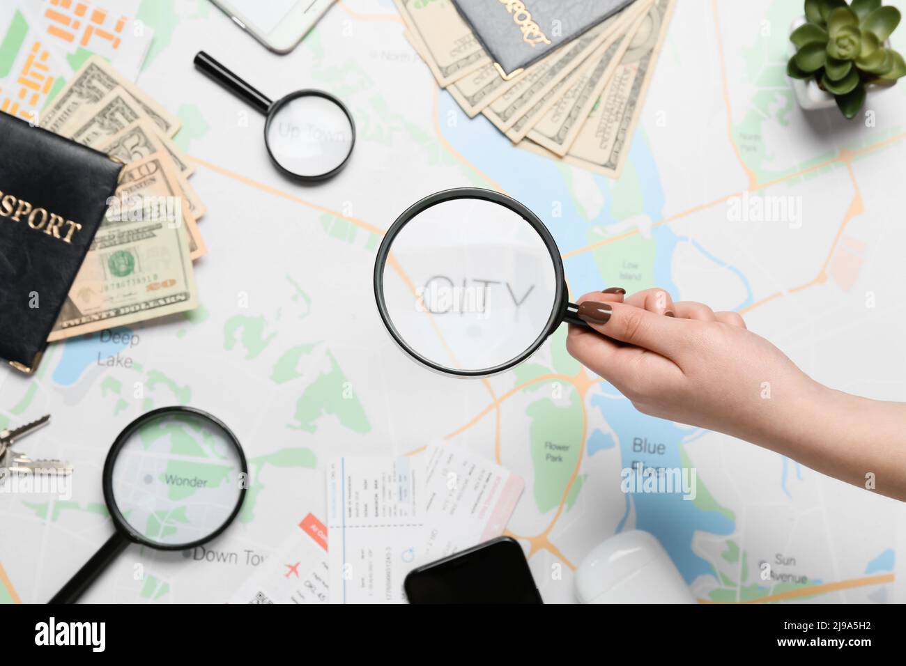 Female guide with magnifier on city map Stock Photo - Alamy