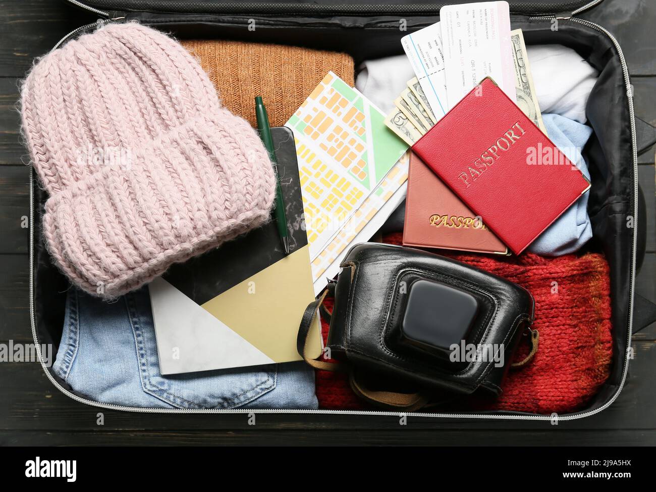 Open suitcase with guide's belongings on dark wooden background Stock ...