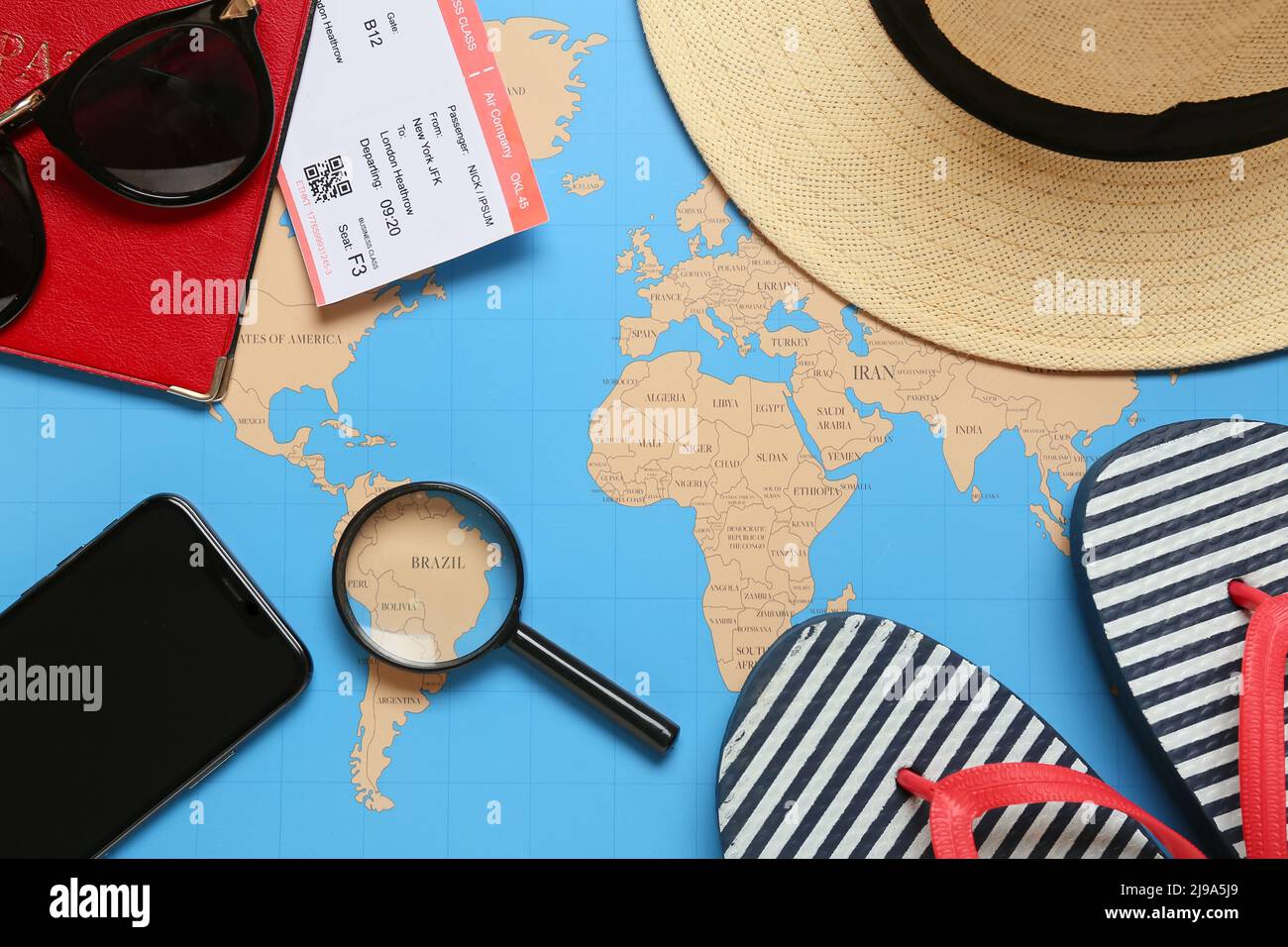 Guide's belongings with magnifier on world map Stock Photo - Alamy