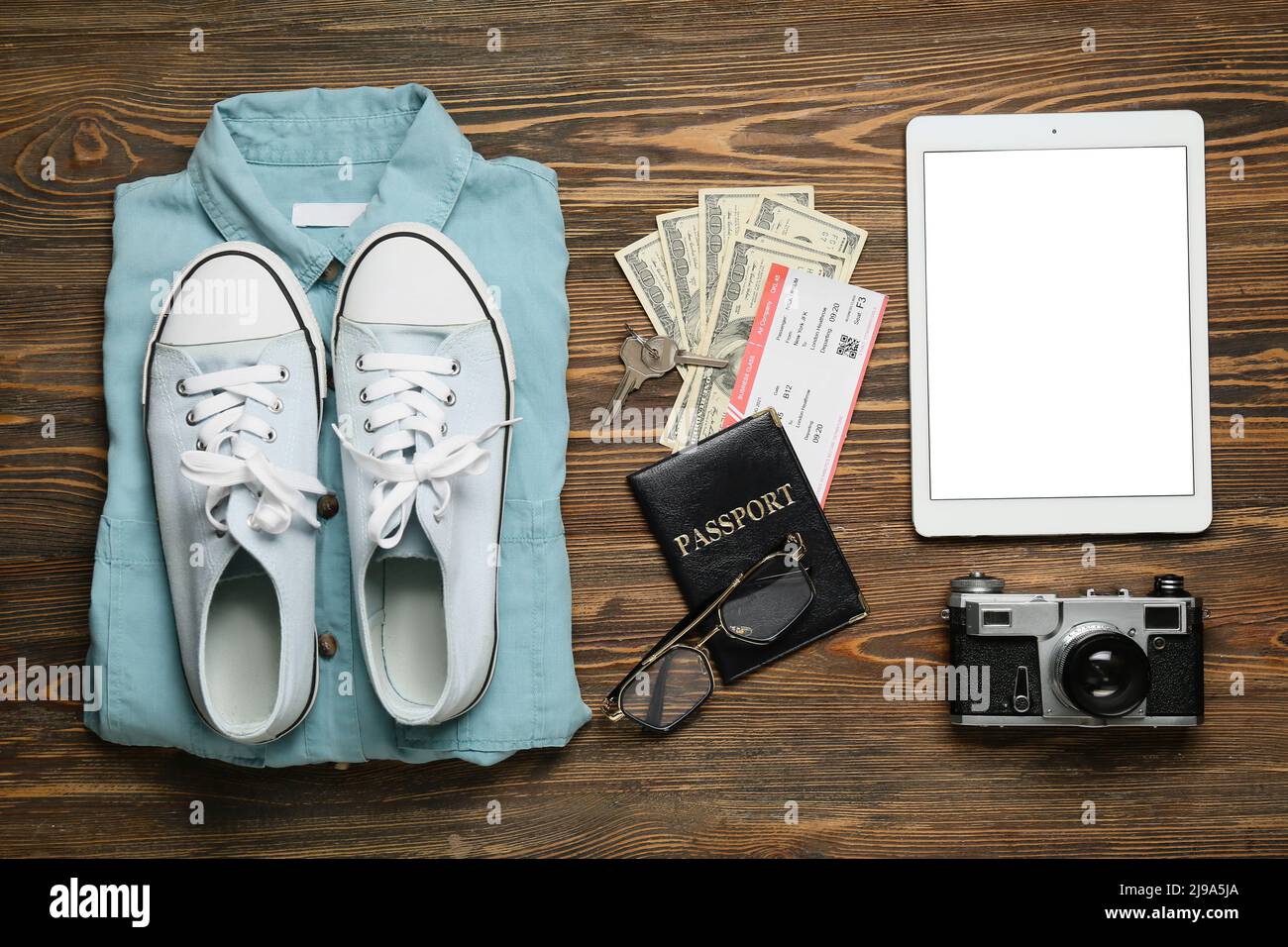 Guide's belongings with tablet computer and photo camera on wooden ...