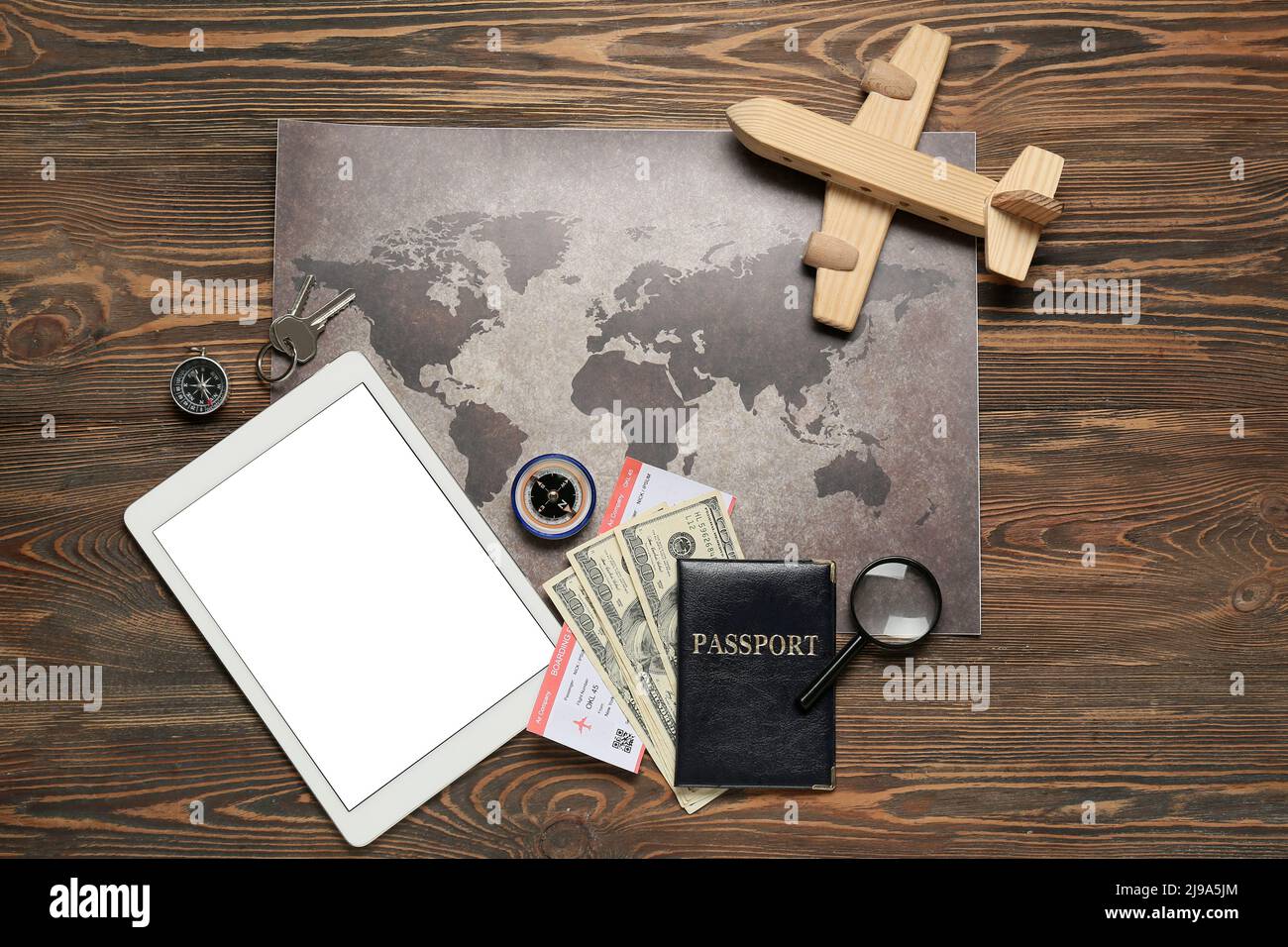 Guide's belongings with world map and tablet computer on wooden ...