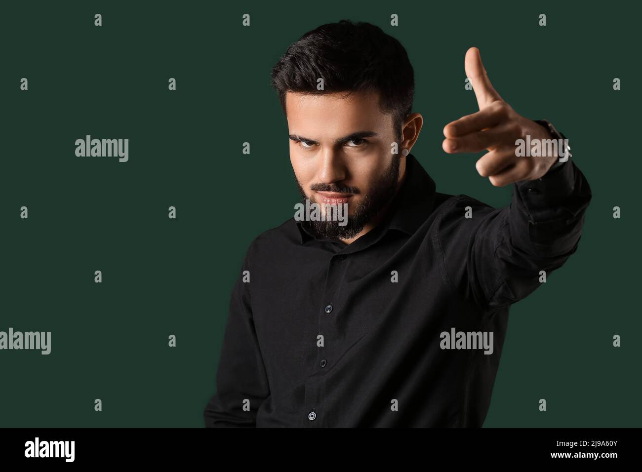 Bearded man pointing fingers gun gesture on color background Stock ...