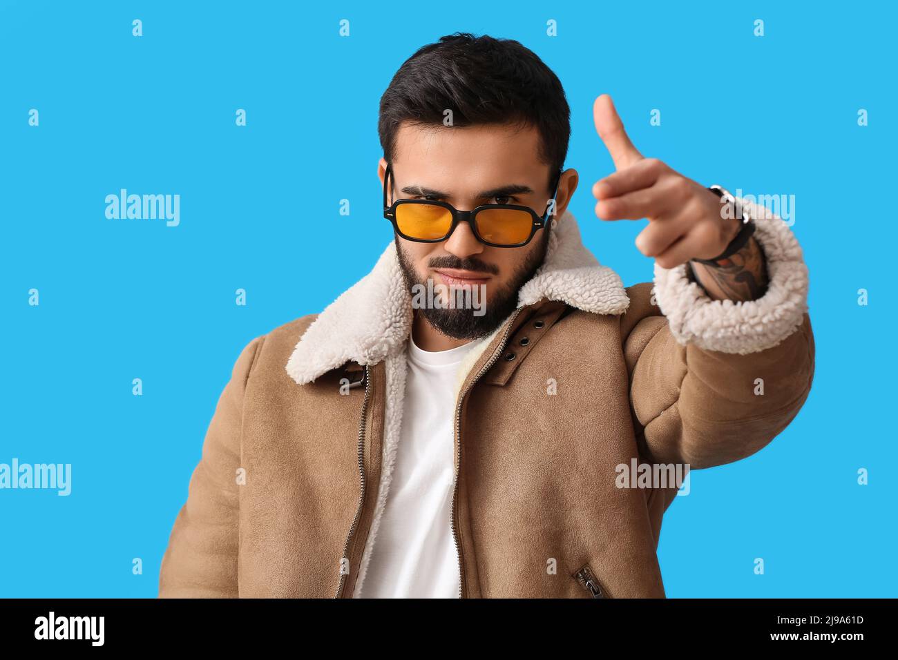 Bearded man pointing at viewer on blue background Stock Photo - Alamy