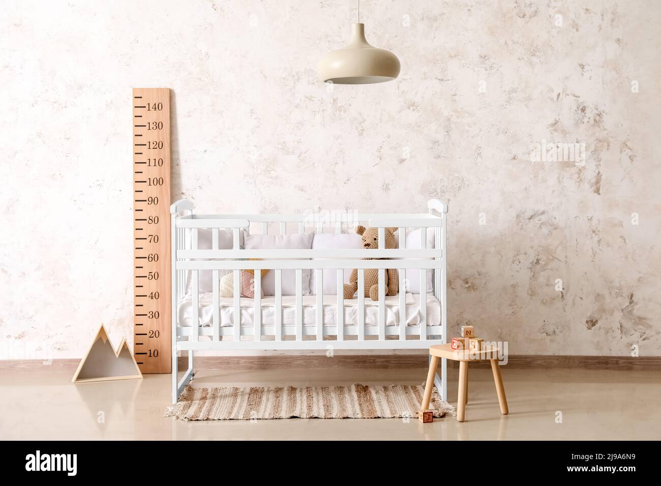 Interior of light nursery with baby crib, stadiometer and stool Stock ...