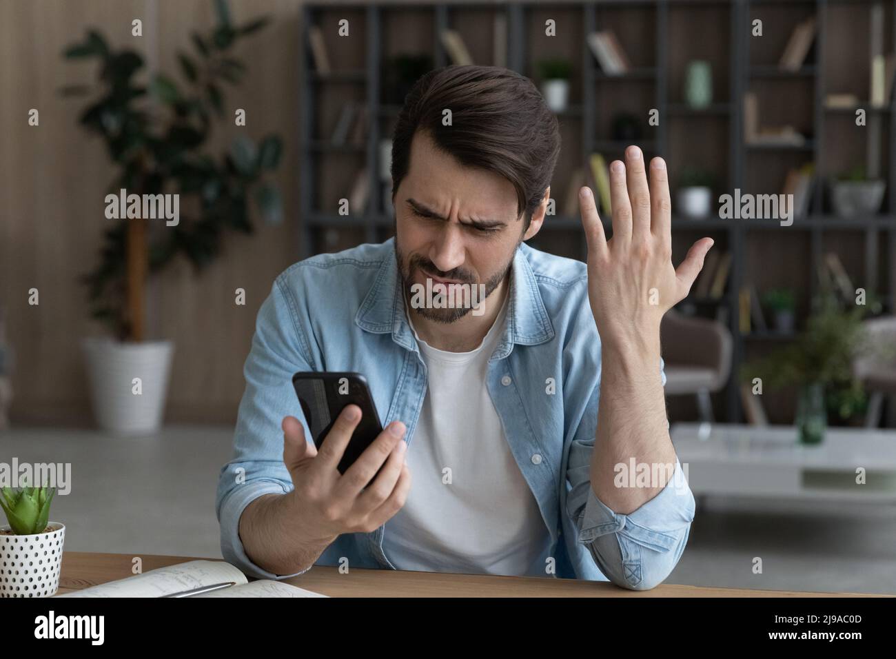 Angry millennial male outraged by wrong work of smartphone app Stock ...