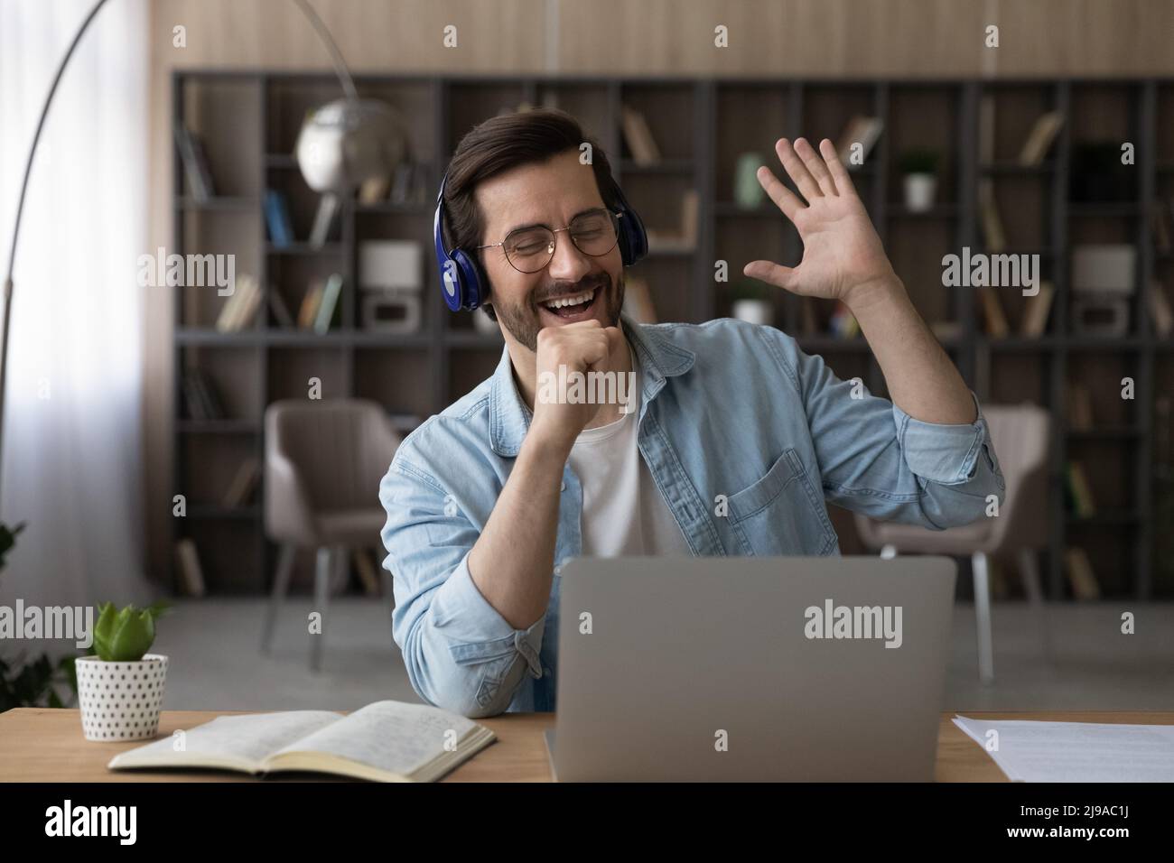 Young guy wear headset relax from computer work sing song Stock Photo ...