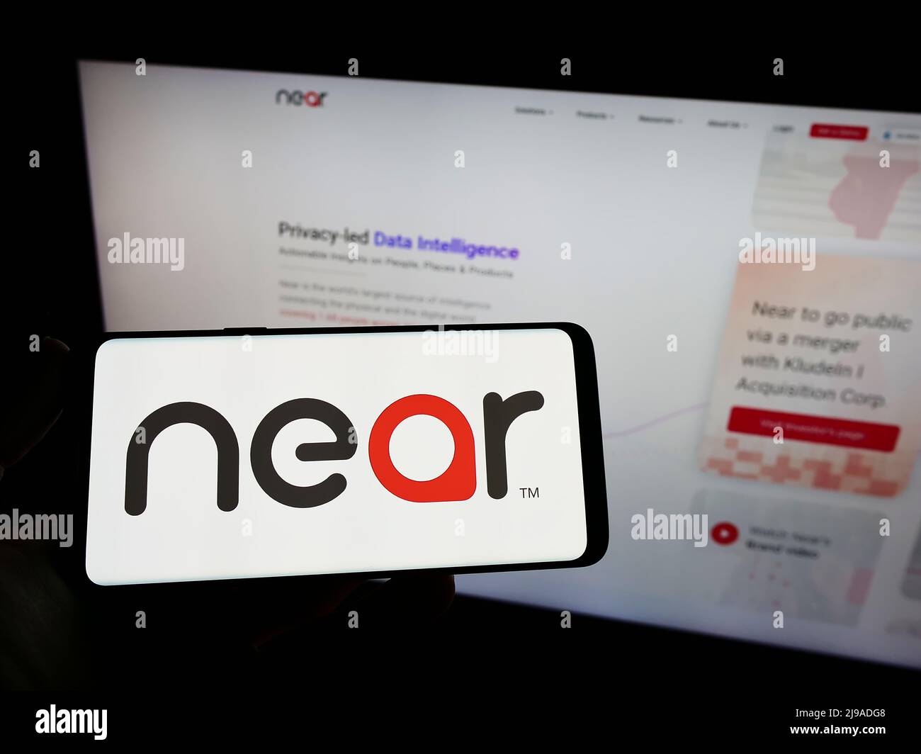 Person holding mobile phone with logo of American analytics company ...