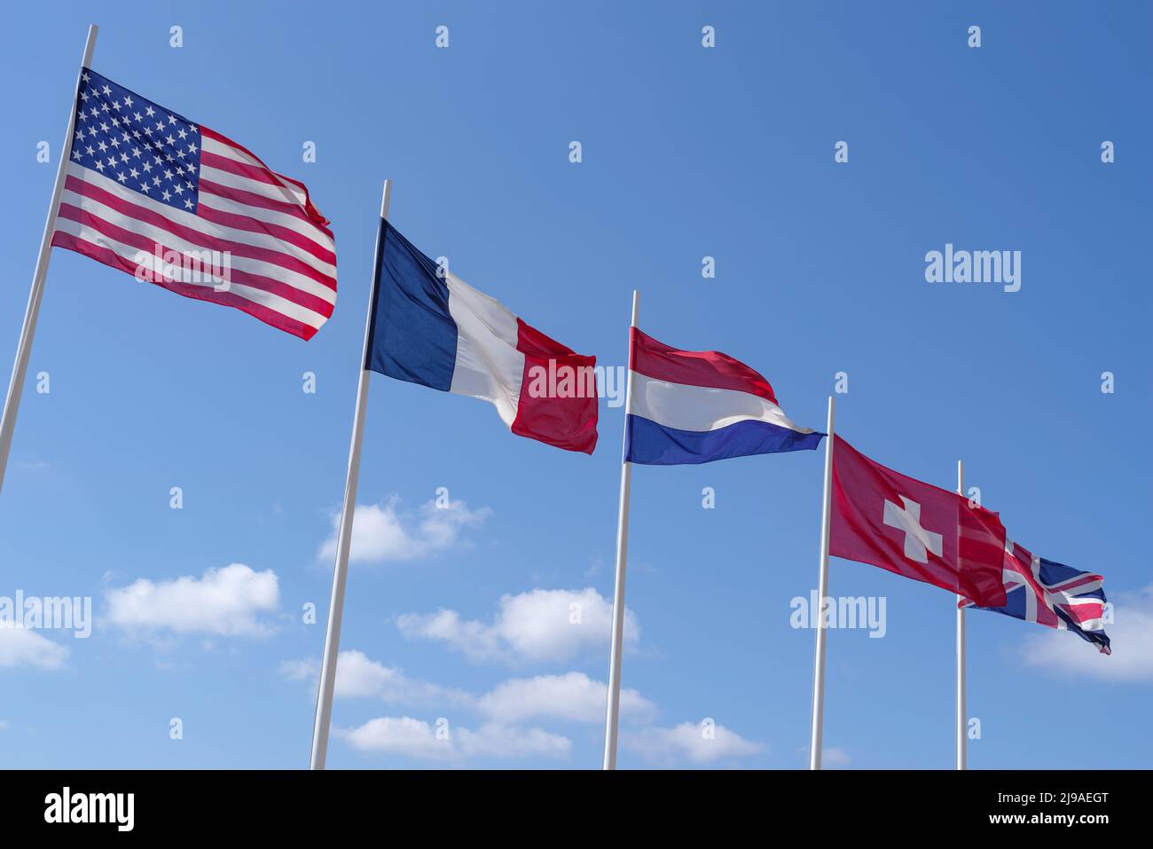 Low angle view of National flags waving against sky Stock Photo - Alamy