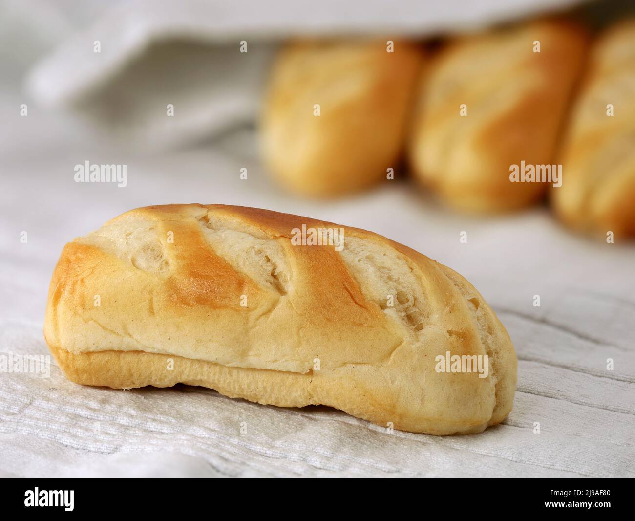 close up of single french milk bun isolated on gray kitchen towel ...
