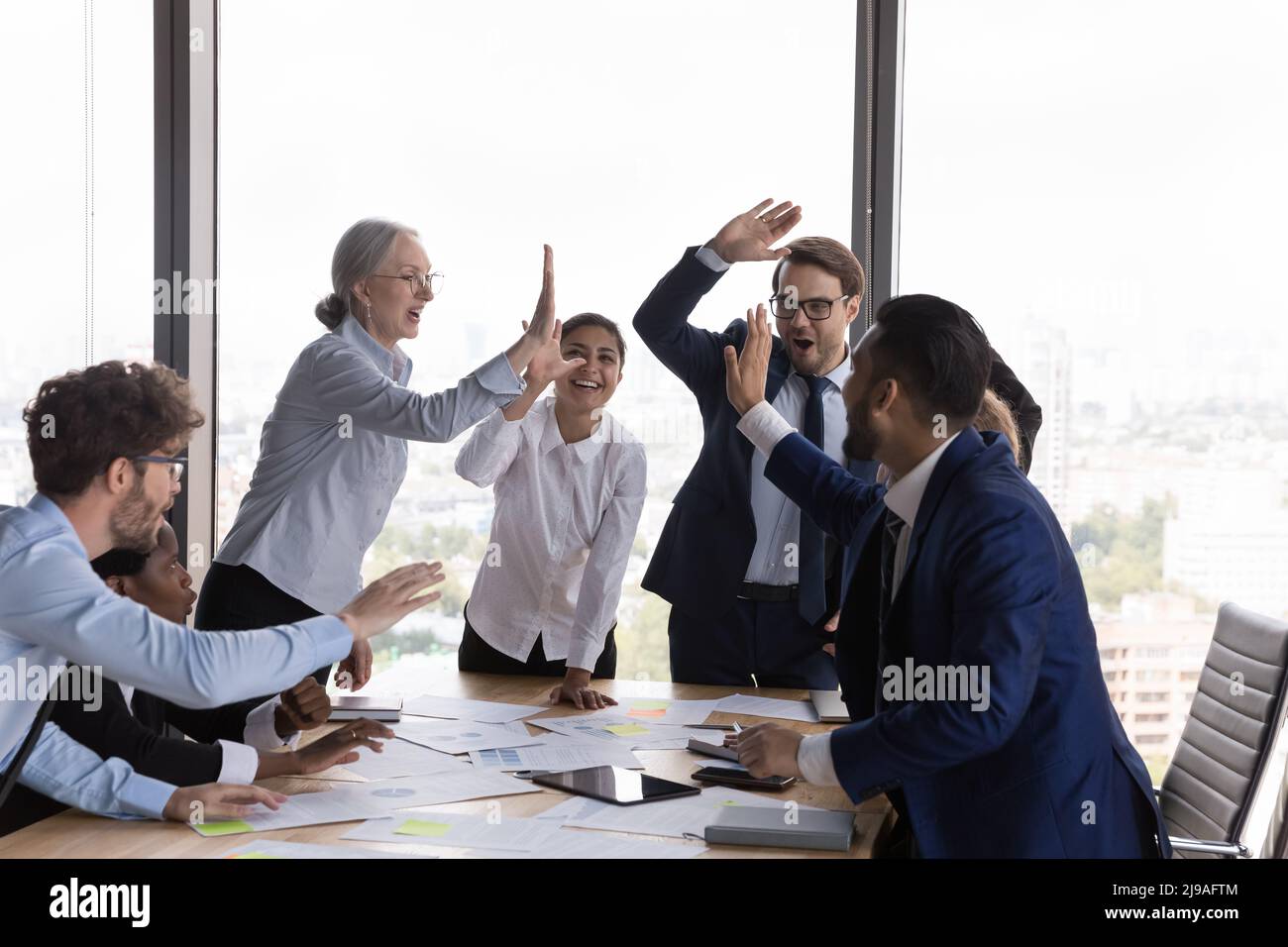 Team of multiethnic employees giving high five at group meeting Stock ...