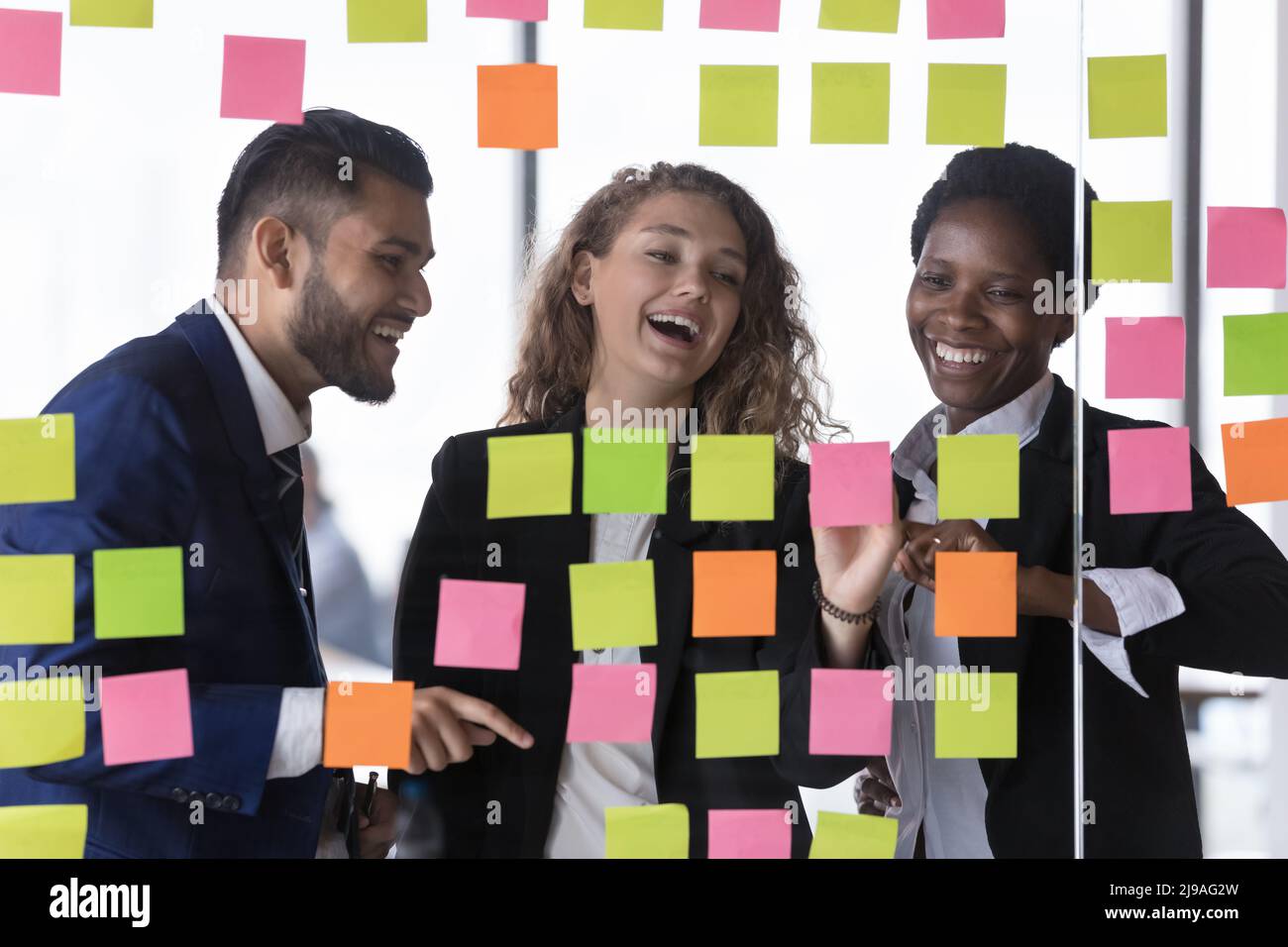 Overjoyed diverse colleagues work together review tasks written on ...