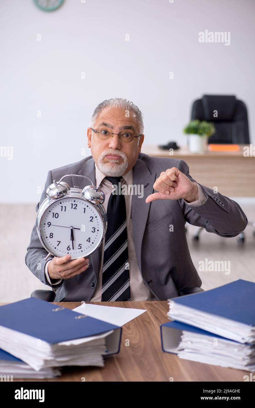 Old male boss in time management concept Stock Photo - Alamy