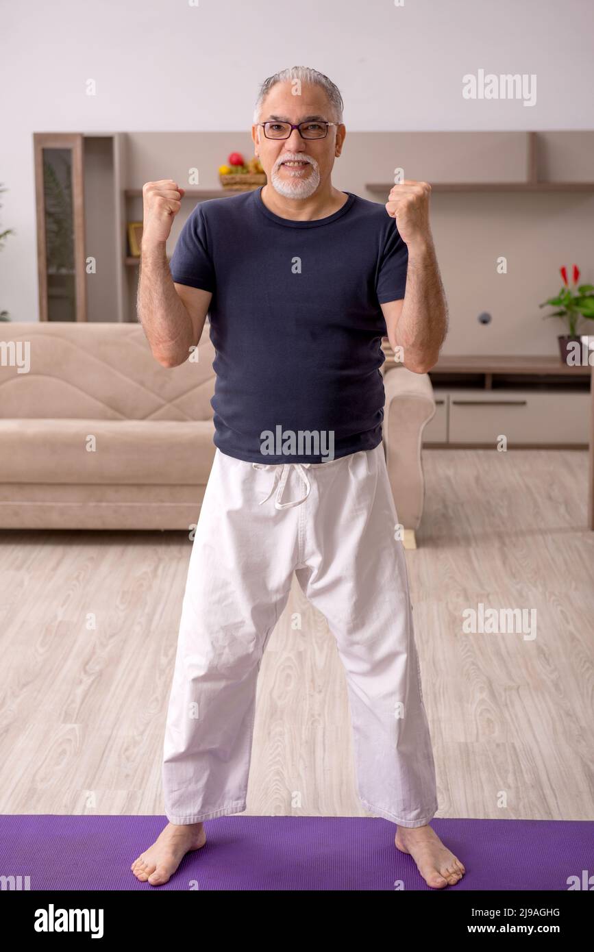 Old man doing sport exercises indoors Stock Photo - Alamy