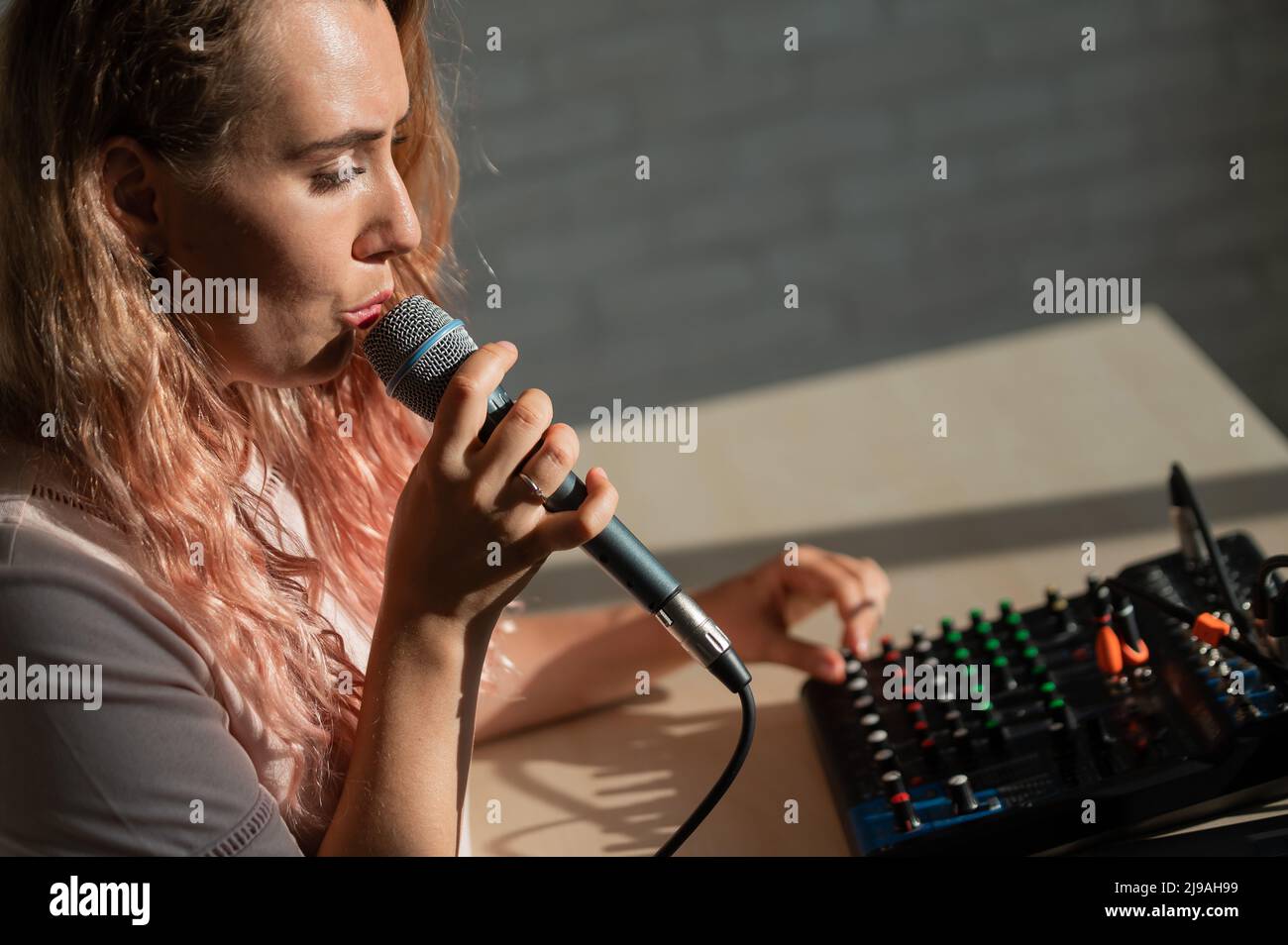 A woman sings a song into a microphone and records her singing Stock ...
