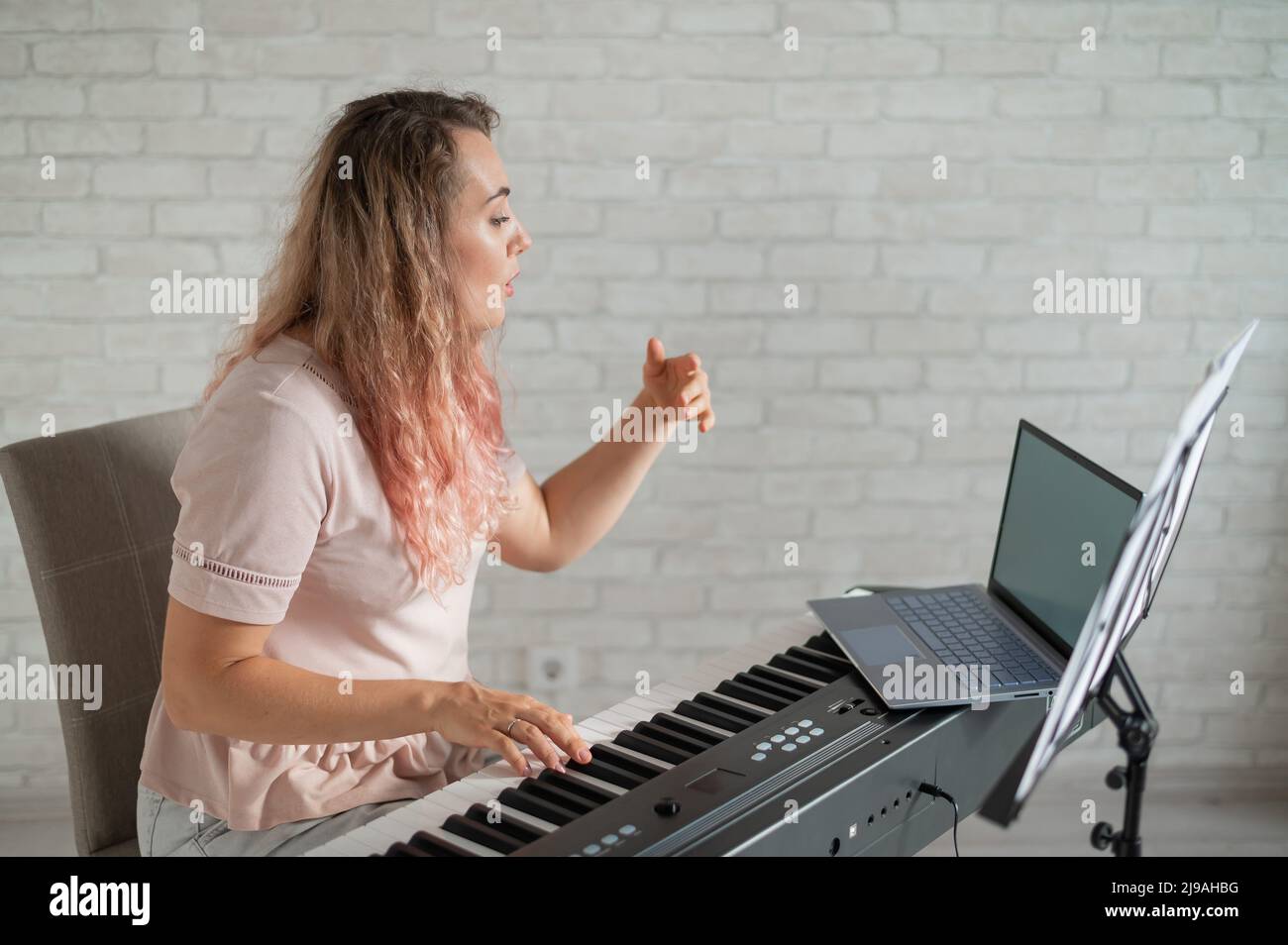 Remote music lessons. A singing teacher records the lesson on a laptop ...