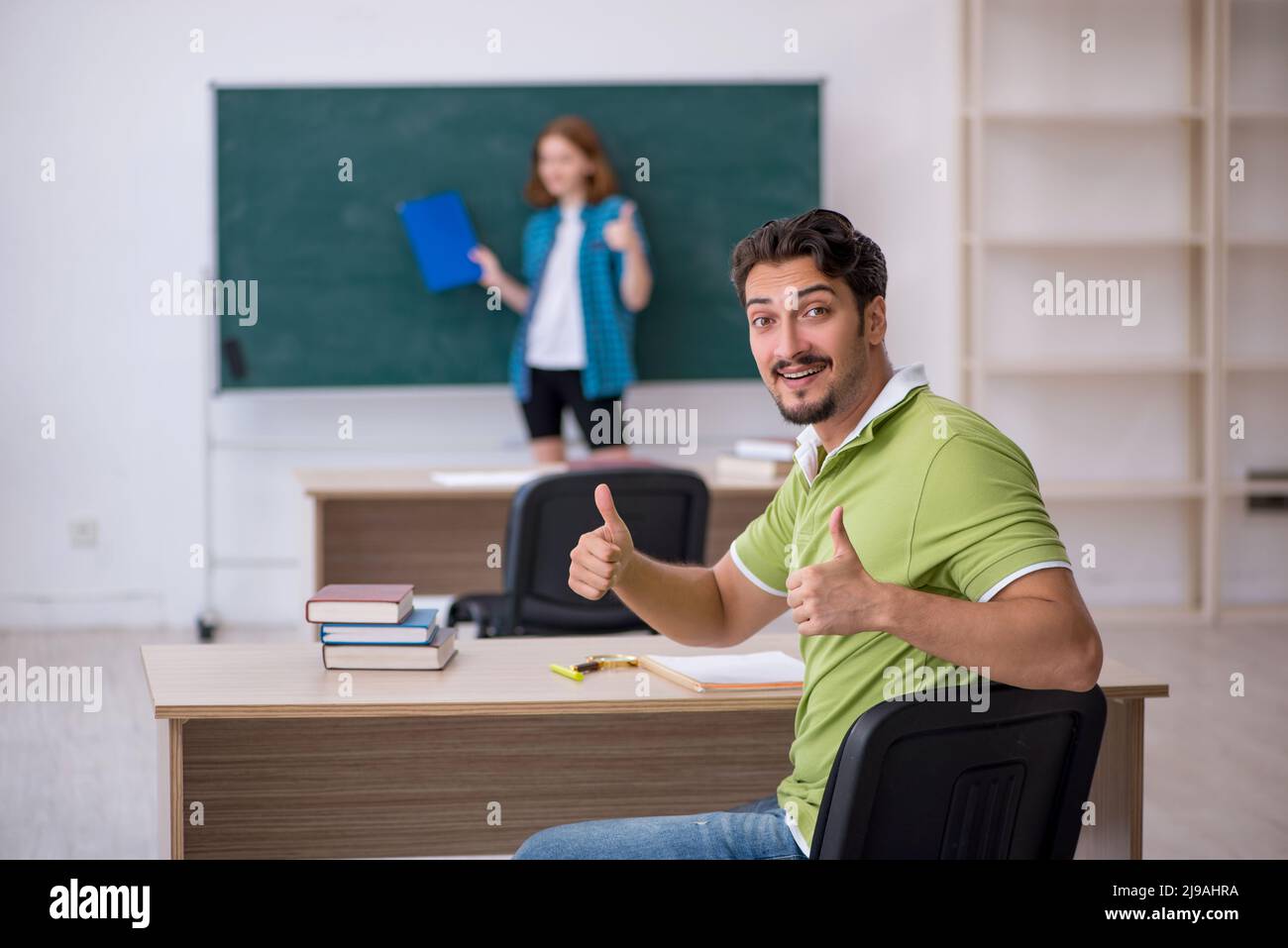 Young teacher teaching student in the classroom Stock Photo - Alamy