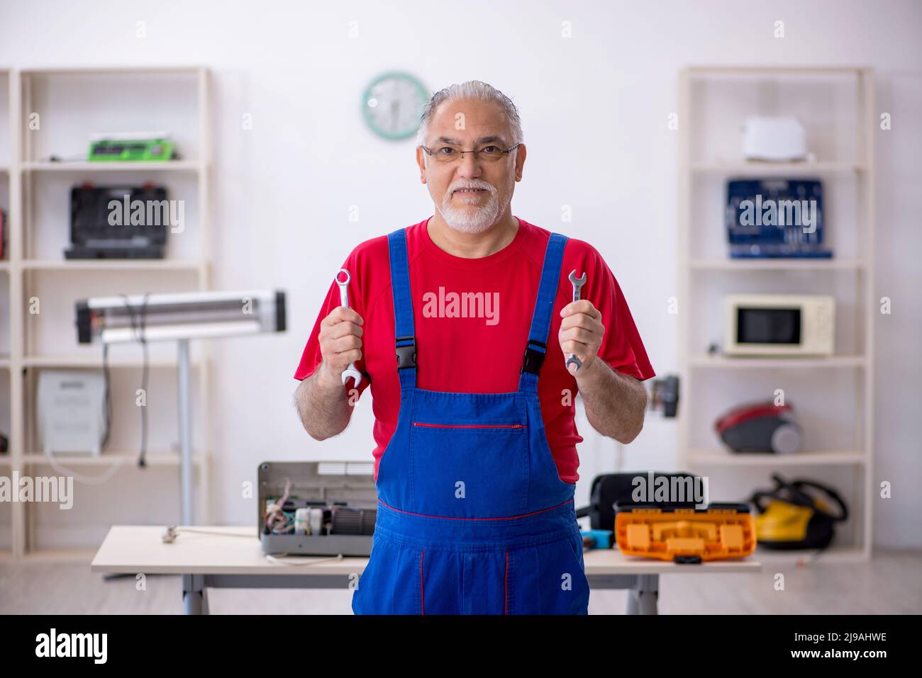 Old male repairman repairing air-conditioner Stock Photo - Alamy