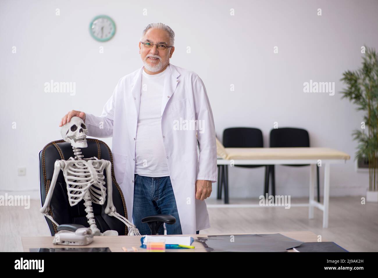 Old doctor with skeleton at the hospital Stock Photo - Alamy