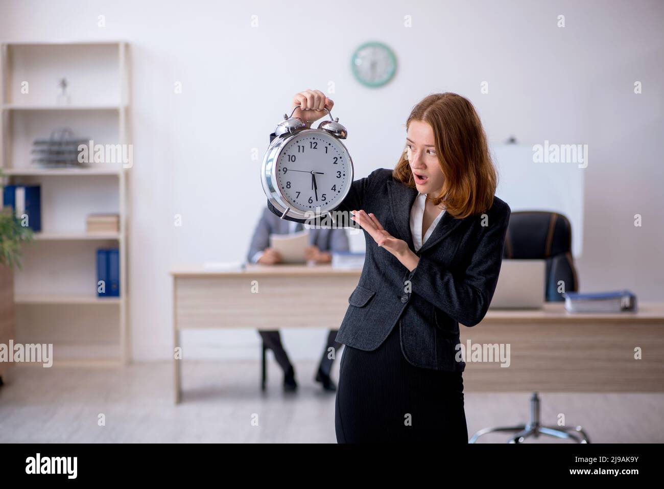 Two colleagues working in the workplace in time management concept ...